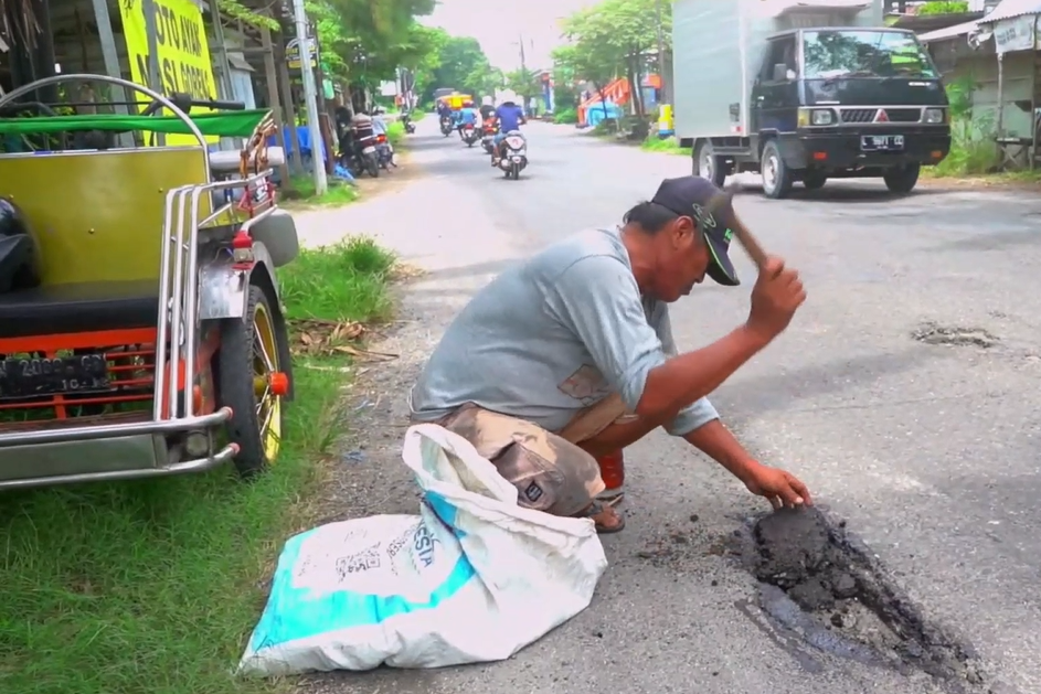 Lindungi Putrinya dari Kecelakaan, Tukang Becak Tambal Jalan Berlubang